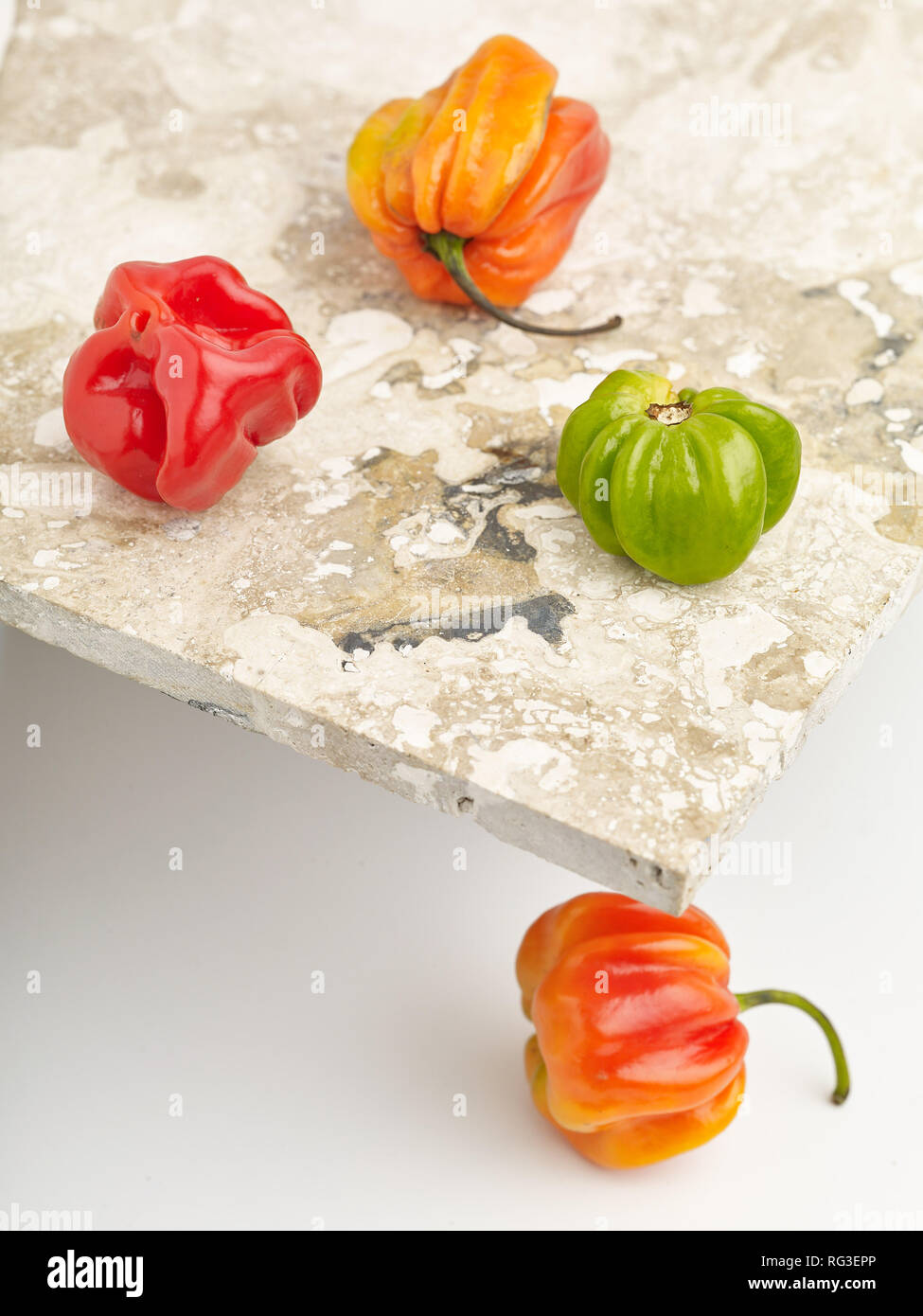 Scotch bonnet pepper and mottled marble surface against light ...