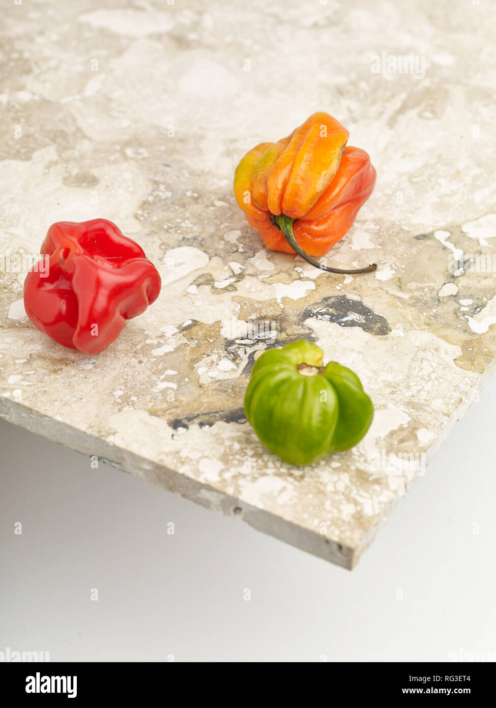 Scotch bonnet pepper and mottled marble surface against light ...