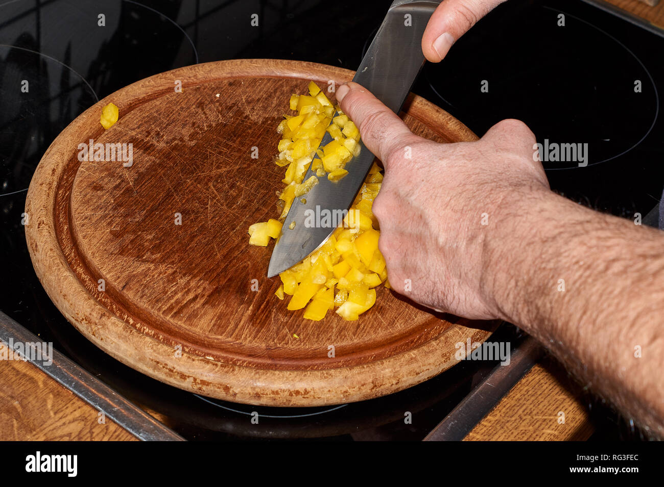 Yellow peppers Capsicum cut with a knife on a board Stock Photo - Alamy
