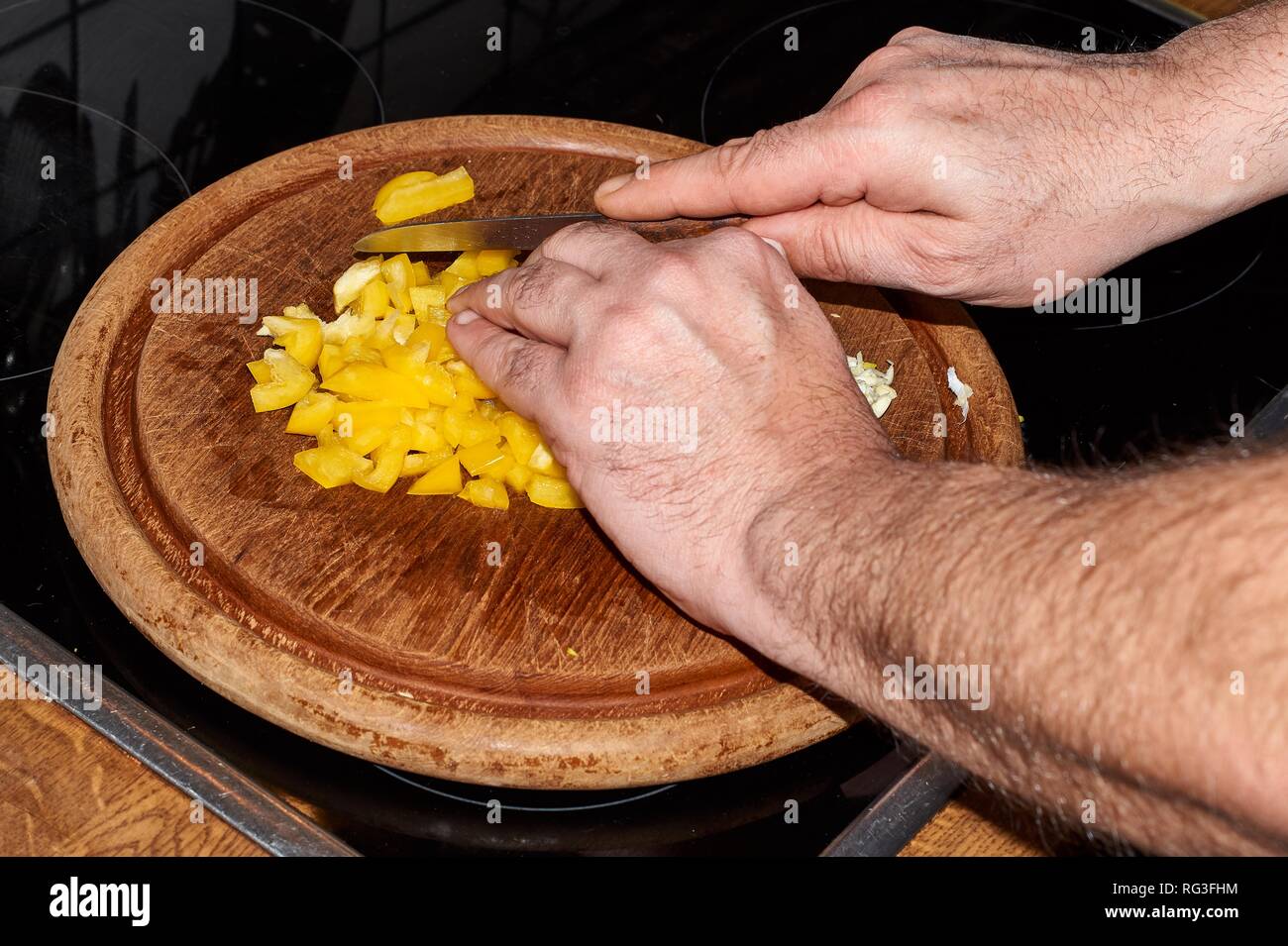 Yellow peppers Capsicum cut with a knife on a board Stock Photo - Alamy