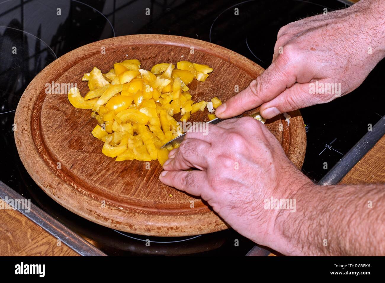 Yellow peppers Capsicum cut with a knife on a board Stock Photo - Alamy