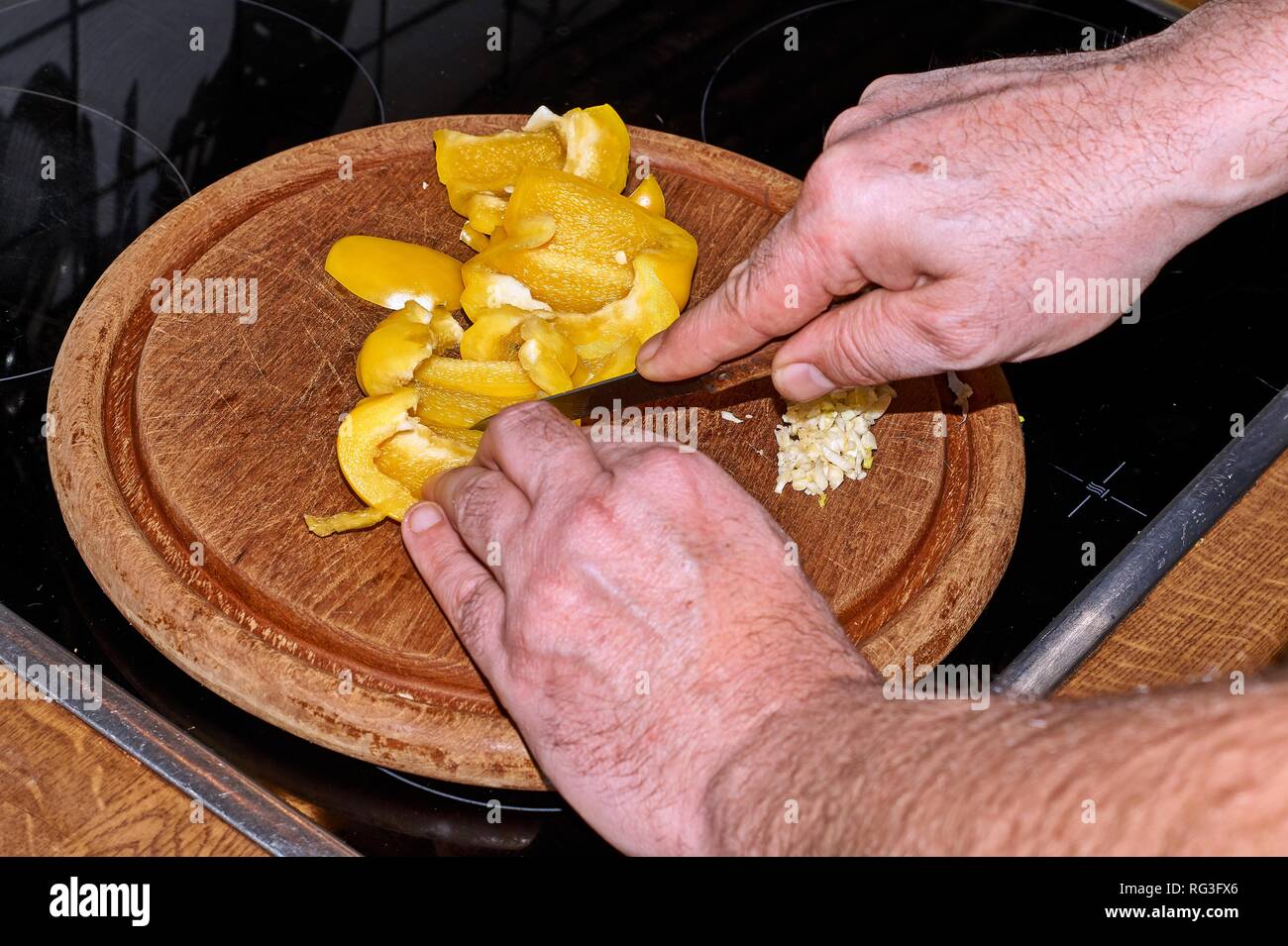 Yellow peppers Capsicum cut with a knife on a board Stock Photo - Alamy