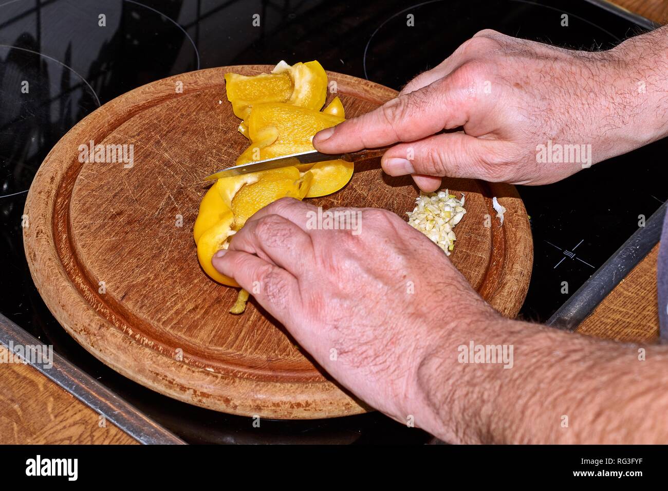 Yellow peppers Capsicum cut with a knife on a board Stock Photo - Alamy
