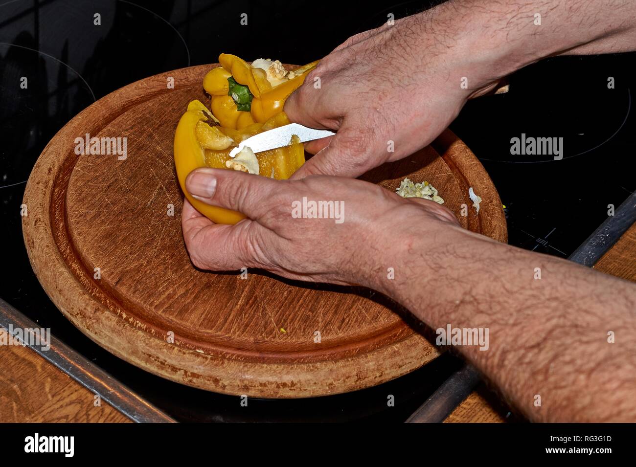 Yellow peppers Capsicum cut with a knife on a board Stock Photo - Alamy