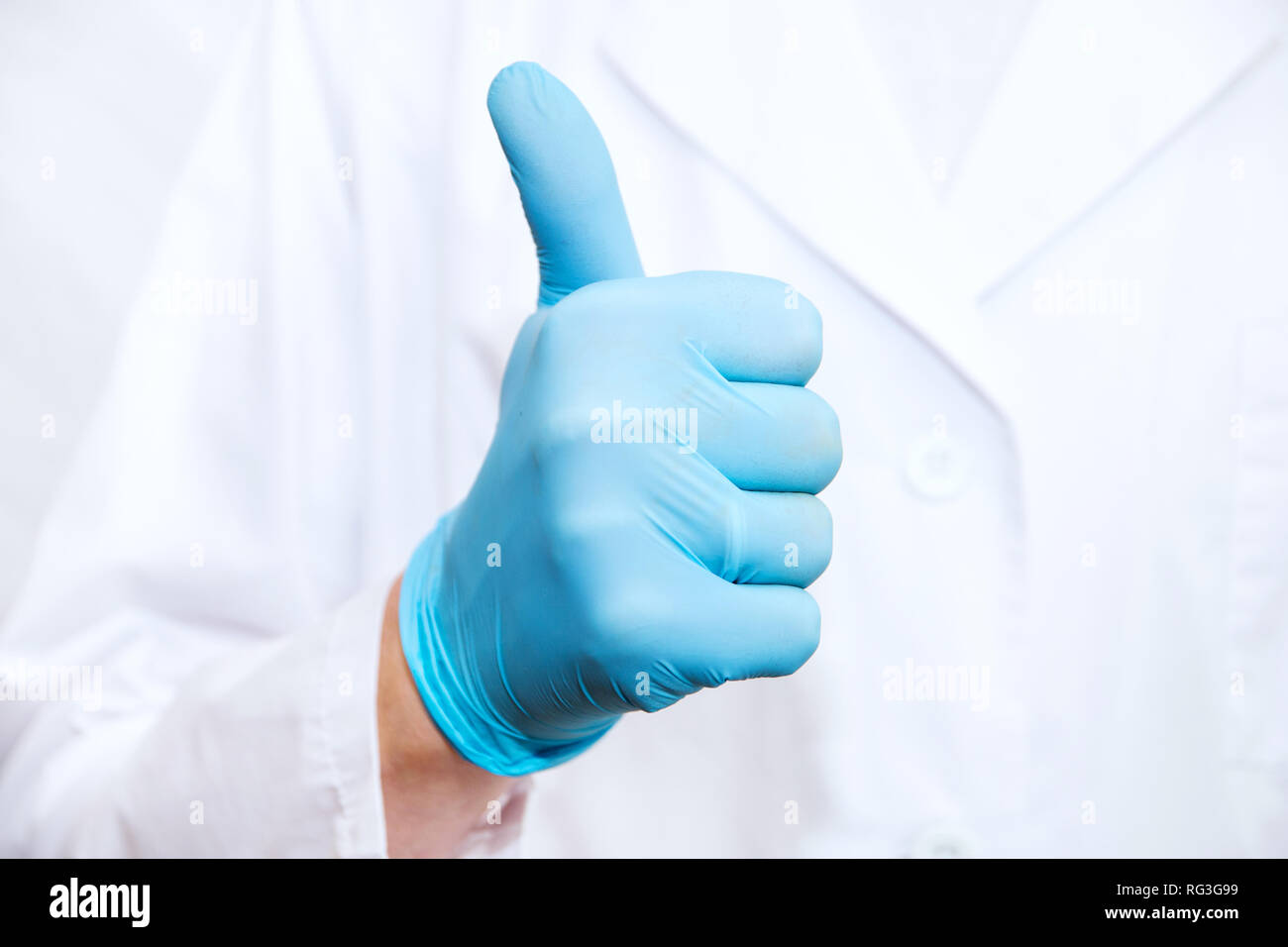 Hand of surgeon in blue medical glove showing Ok sign, isolated on a ...