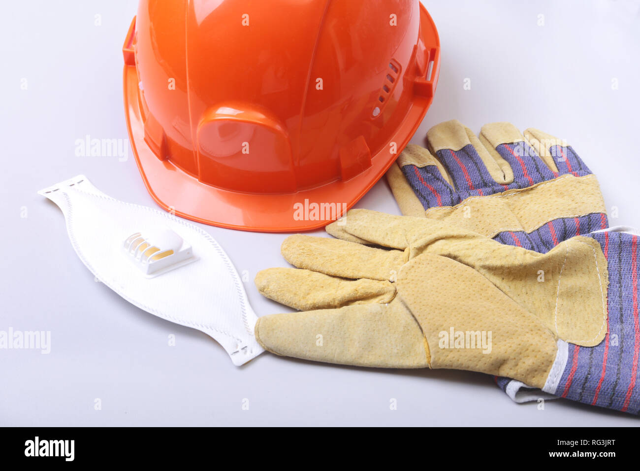 Orange hard hat, goggles, protective mask, respirator and safety gloves ...