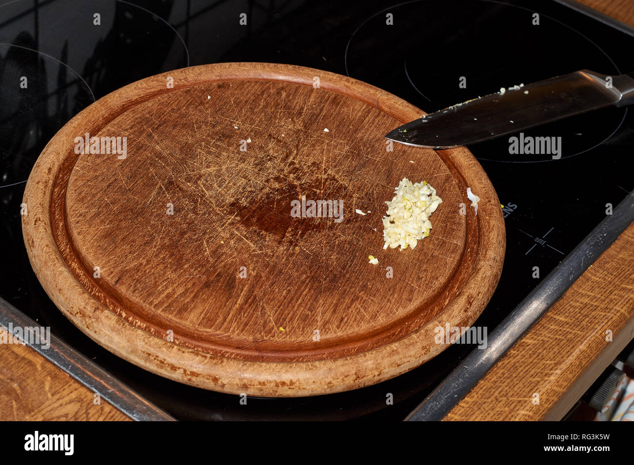 Chef slicing garlic Allium sativum on the cutting board with a knife ...