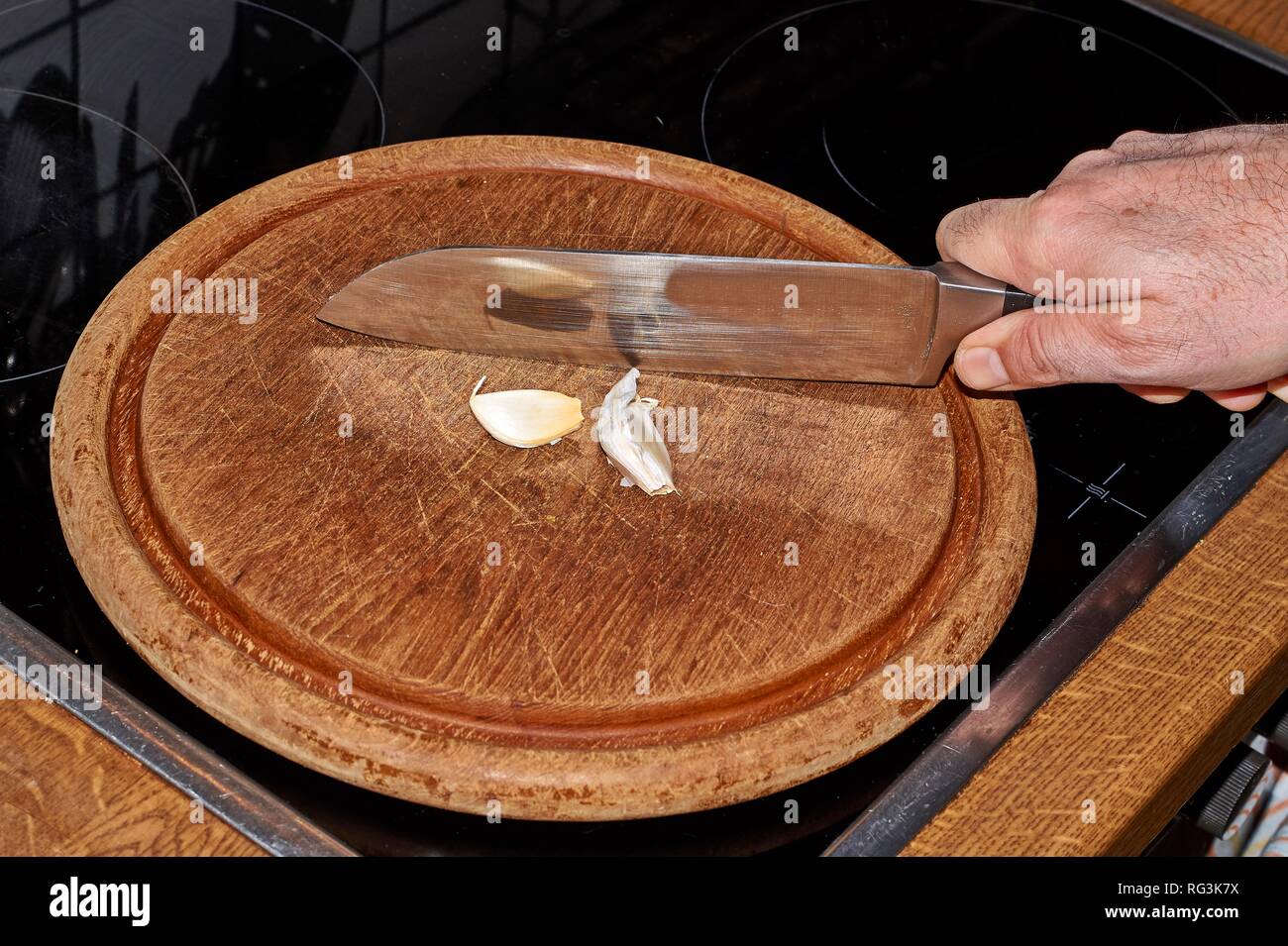 Chef slicing garlic Allium sativum on the cutting board with a knife Stock Photo - Alamy