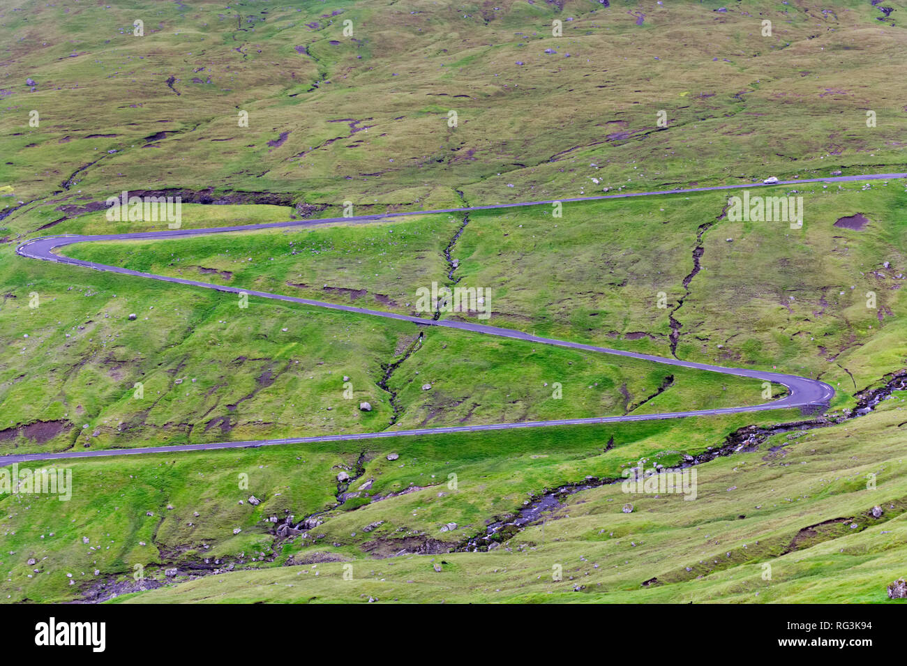 A winding paved road moves around a green countryside Stock Photo - Alamy