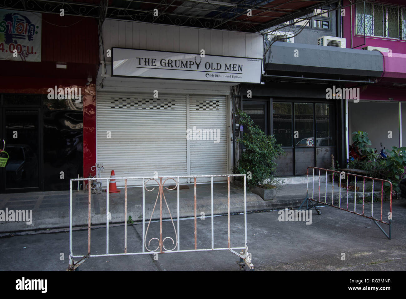 Grumpy old men shop or bar Thailand Asia barrier barriers closed metal ...