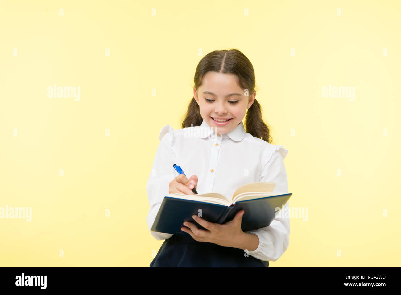 Making notes. Child school uniform kid doing homework. Child girl ...