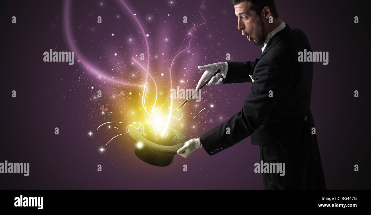 Magician hand conjure with wand light from a black cylinder Stock Photo ...