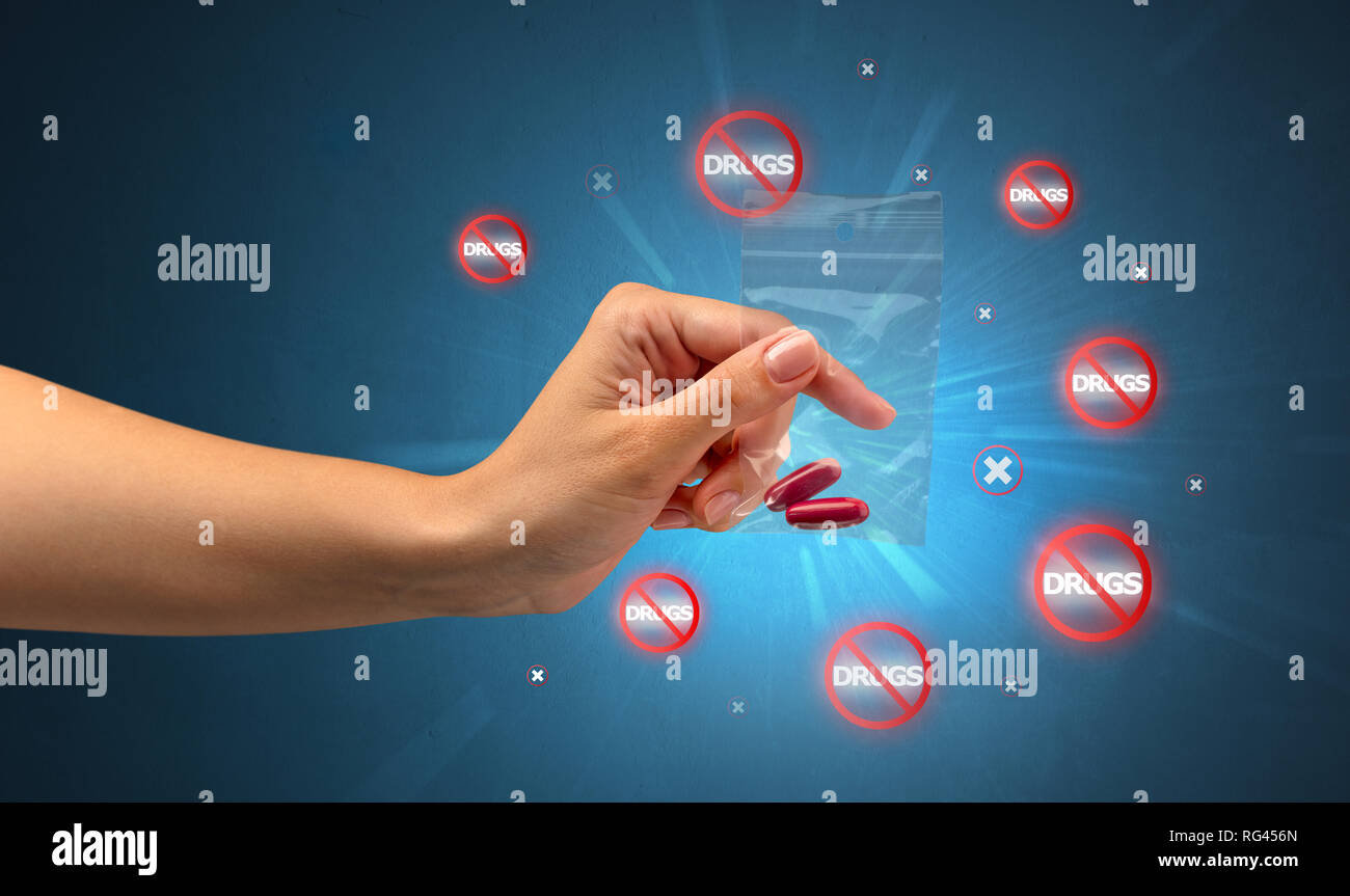 Hand giving pills with anti-drug concept and not allowed signs around ...