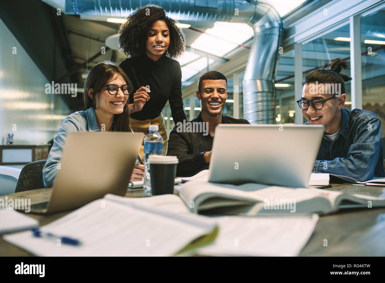 Group of young students studying together using laptop. University ...