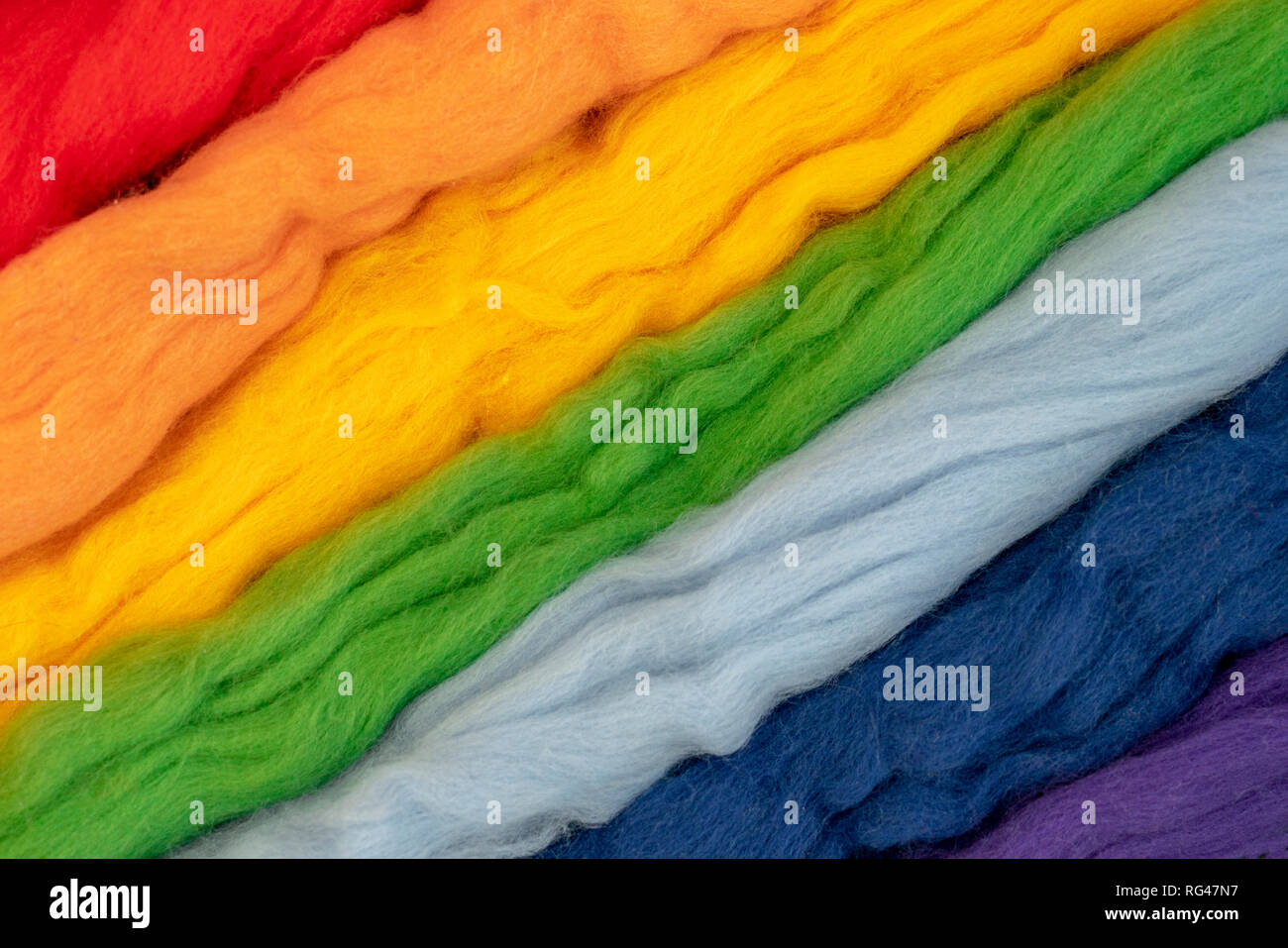 Tufts of wool of different colors parallel to each other form a rainbow ...