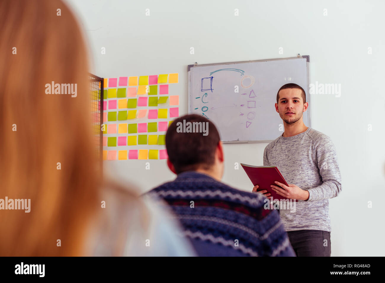 Male student is having a presentation on the board while the other ...