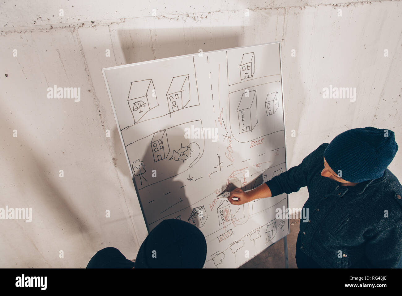 Thiefs standing and drawing a map for robbery Stock Photo - Alamy