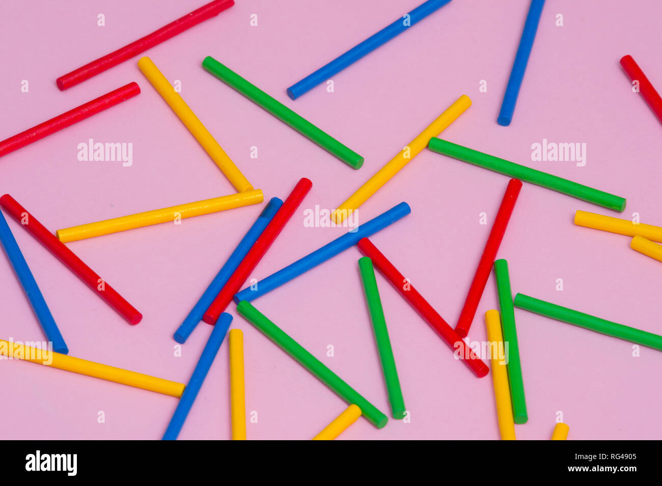 Colorful wooden sticks against pink background Stock Photo - Alamy