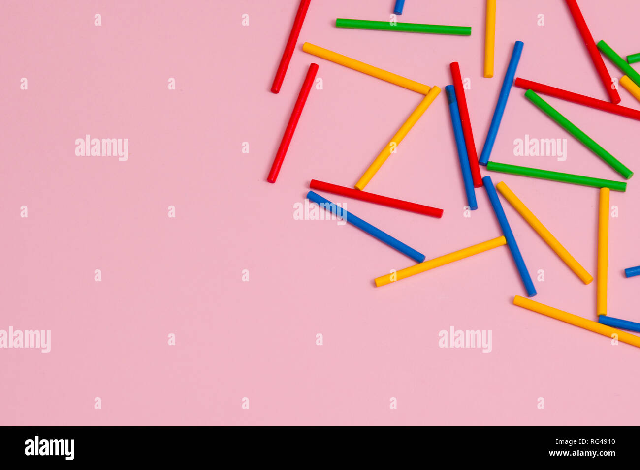 Colorful wooden sticks against pink background Stock Photo - Alamy