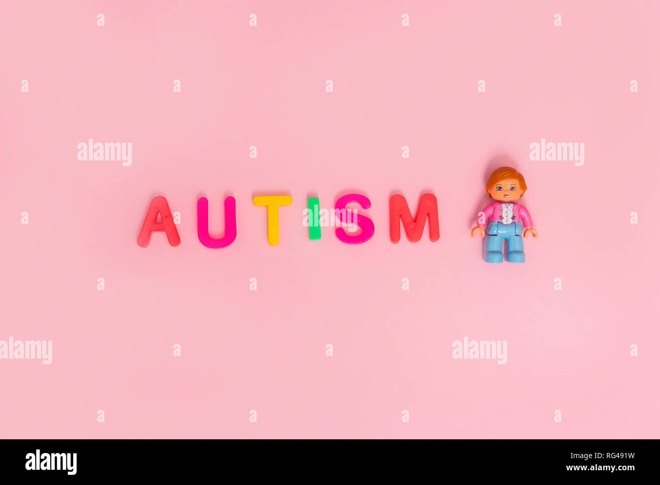 Word AUTISM and toy on pink background, top view Stock Photo - Alamy