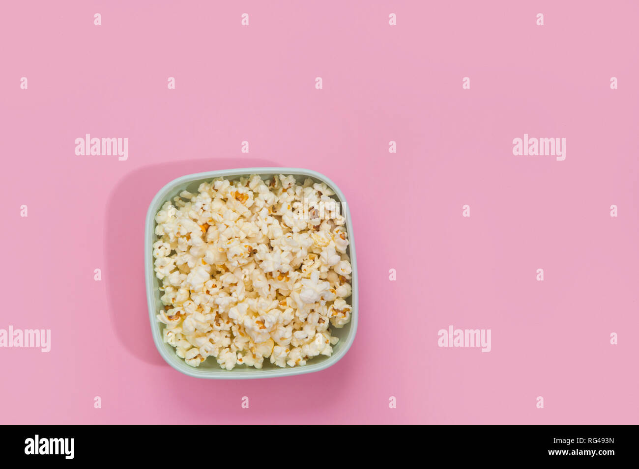 Popcorn bowl viewed from above on pink background. Flat lay. Top view ...