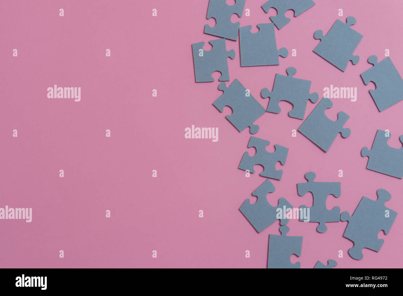 Paper puzzles on a pink background Stock Photo - Alamy