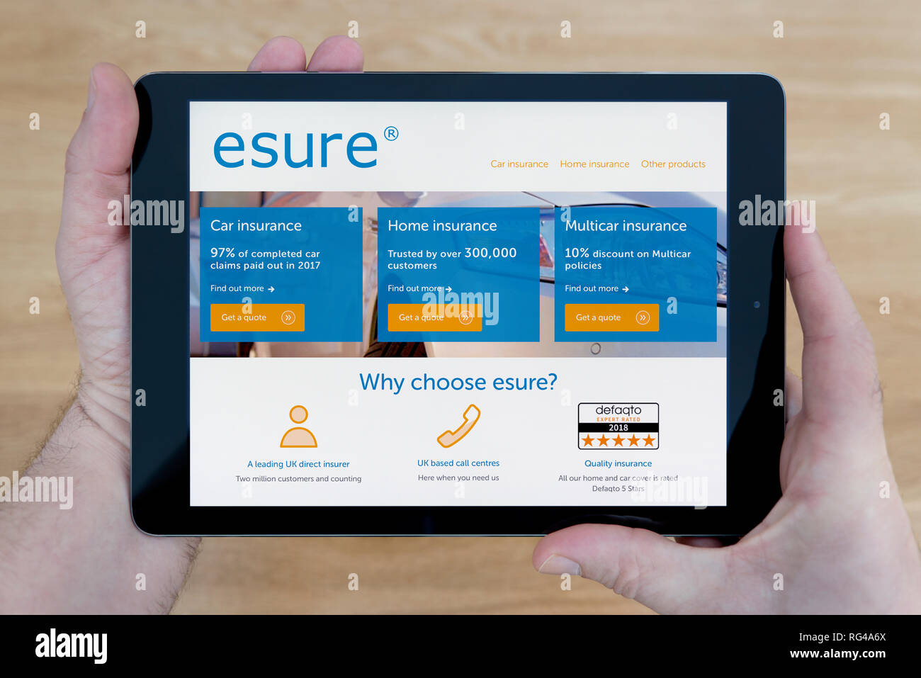 A man looks at the esure website on his iPad tablet device, shot ...