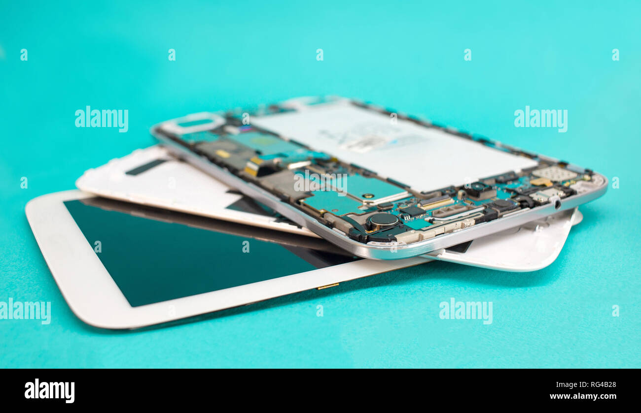 Tablet repair. Close-up disassembled mobile phone parts. Colorful blue ...