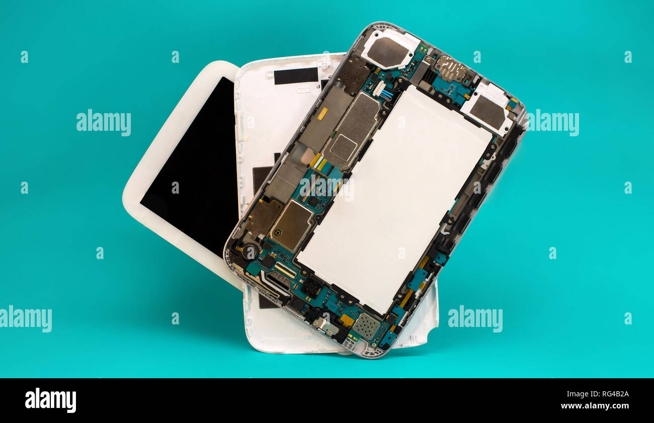 Tablet repair. Close-up disassembled mobile phone parts. Colorful blue ...