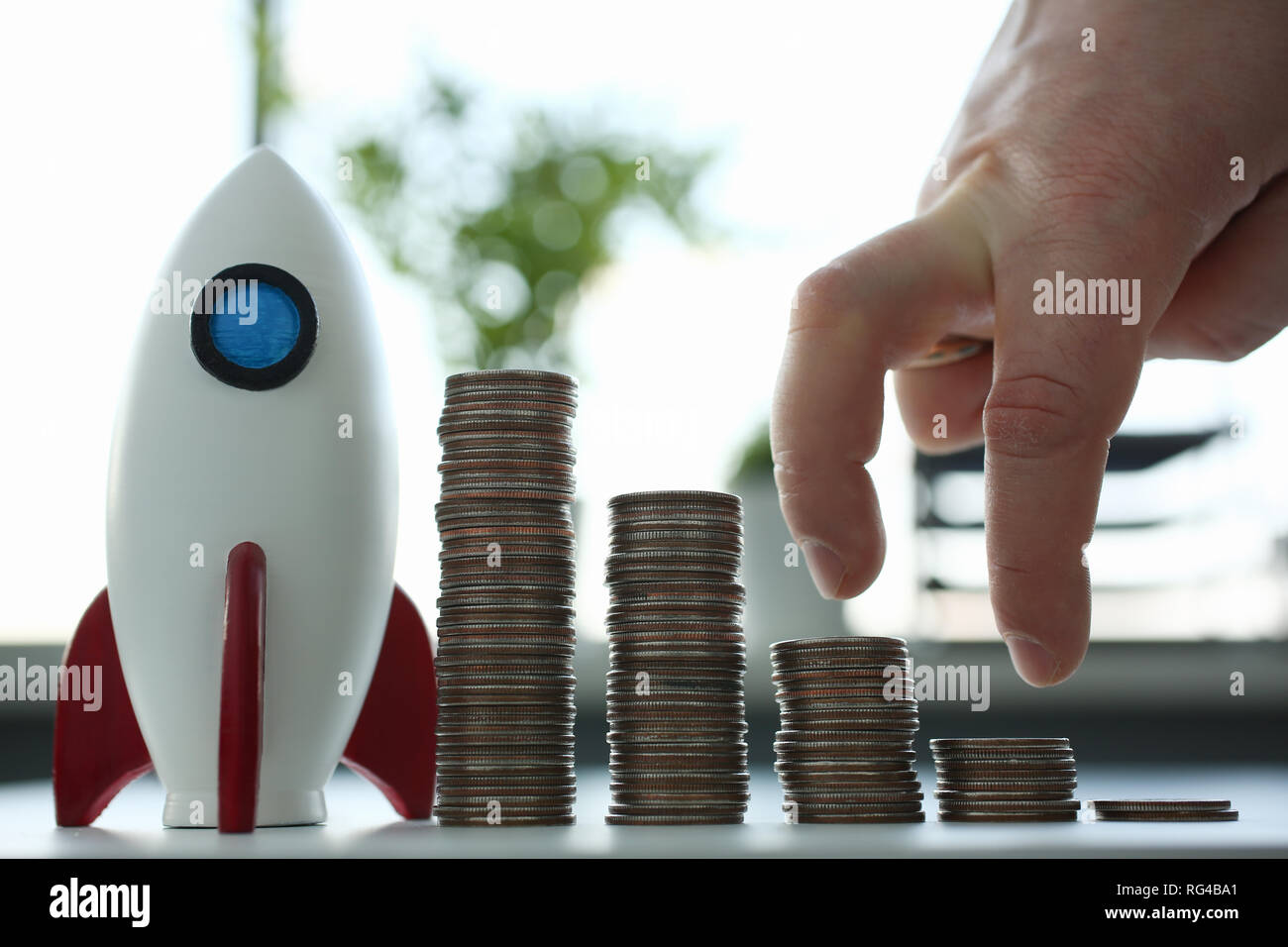 Rocketship stand with coin row ready go to moon Stock Photo - Alamy