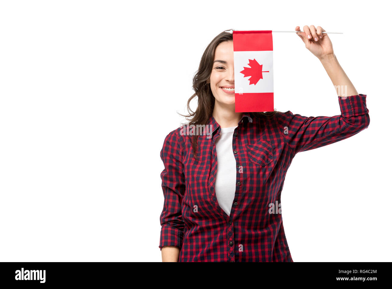 smiling woman holding canadian flag in front of face isolated on white ...
