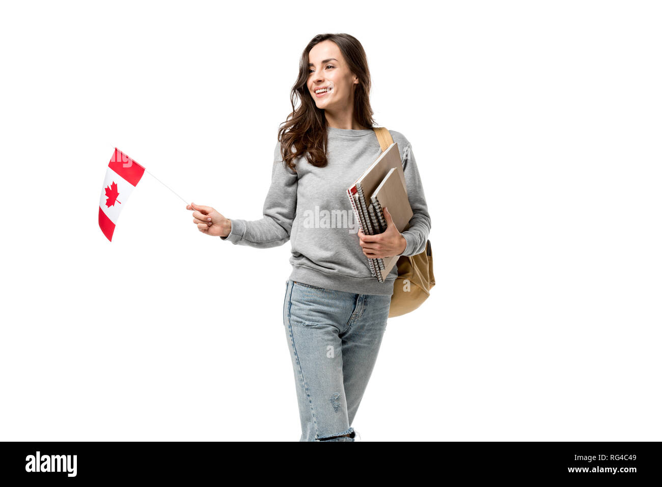smiling female student with backpack and notebooks holding canadian ...