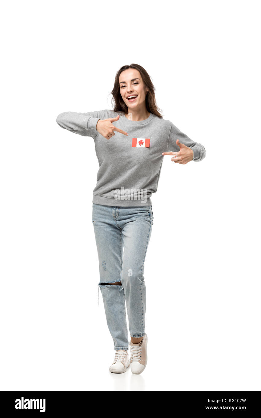 happy woman pointing with fingers at canadian flag badge isolated on ...