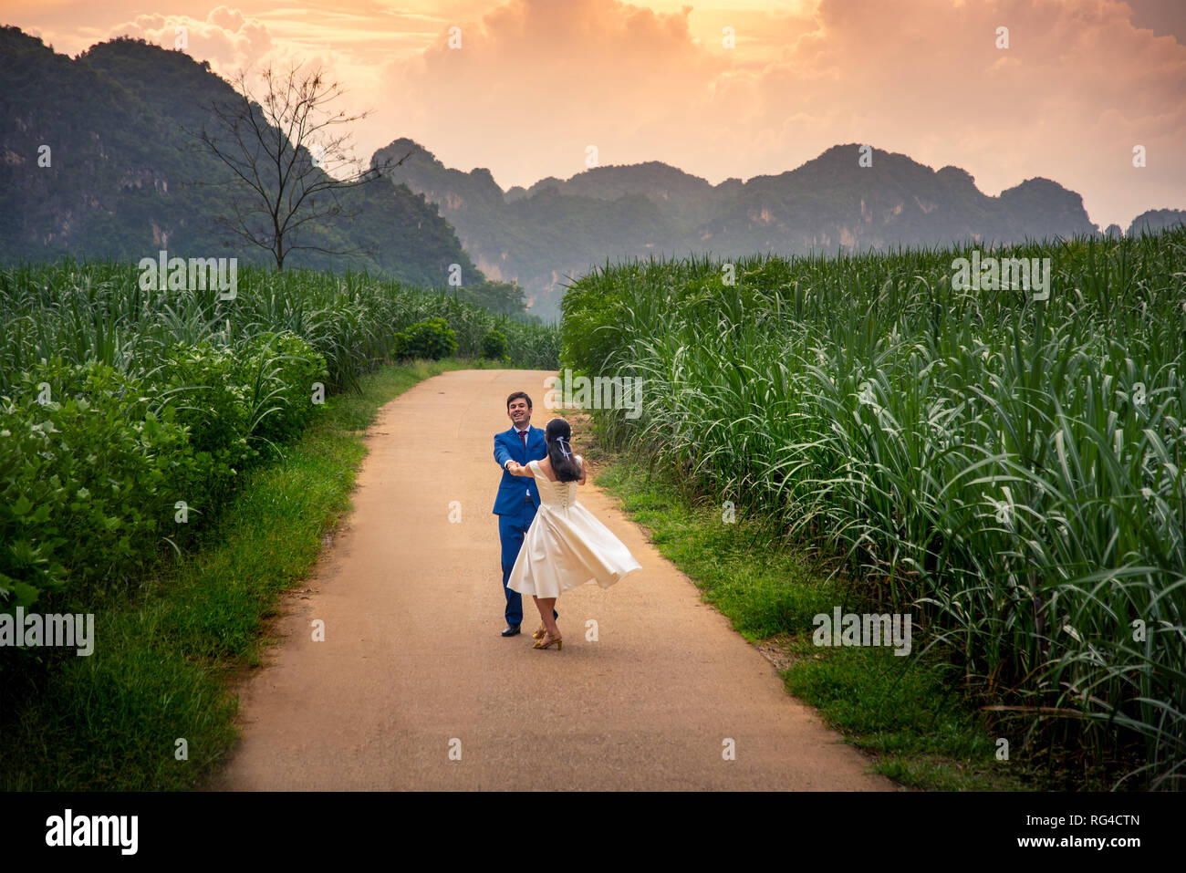 Happy couple having fun in a sugar cane field at sunset Stock Photo - Alamy
