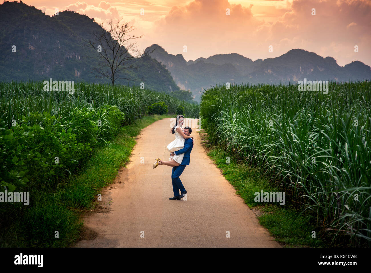 Happy couple having fun in a sugar cane field at sunset Stock Photo - Alamy