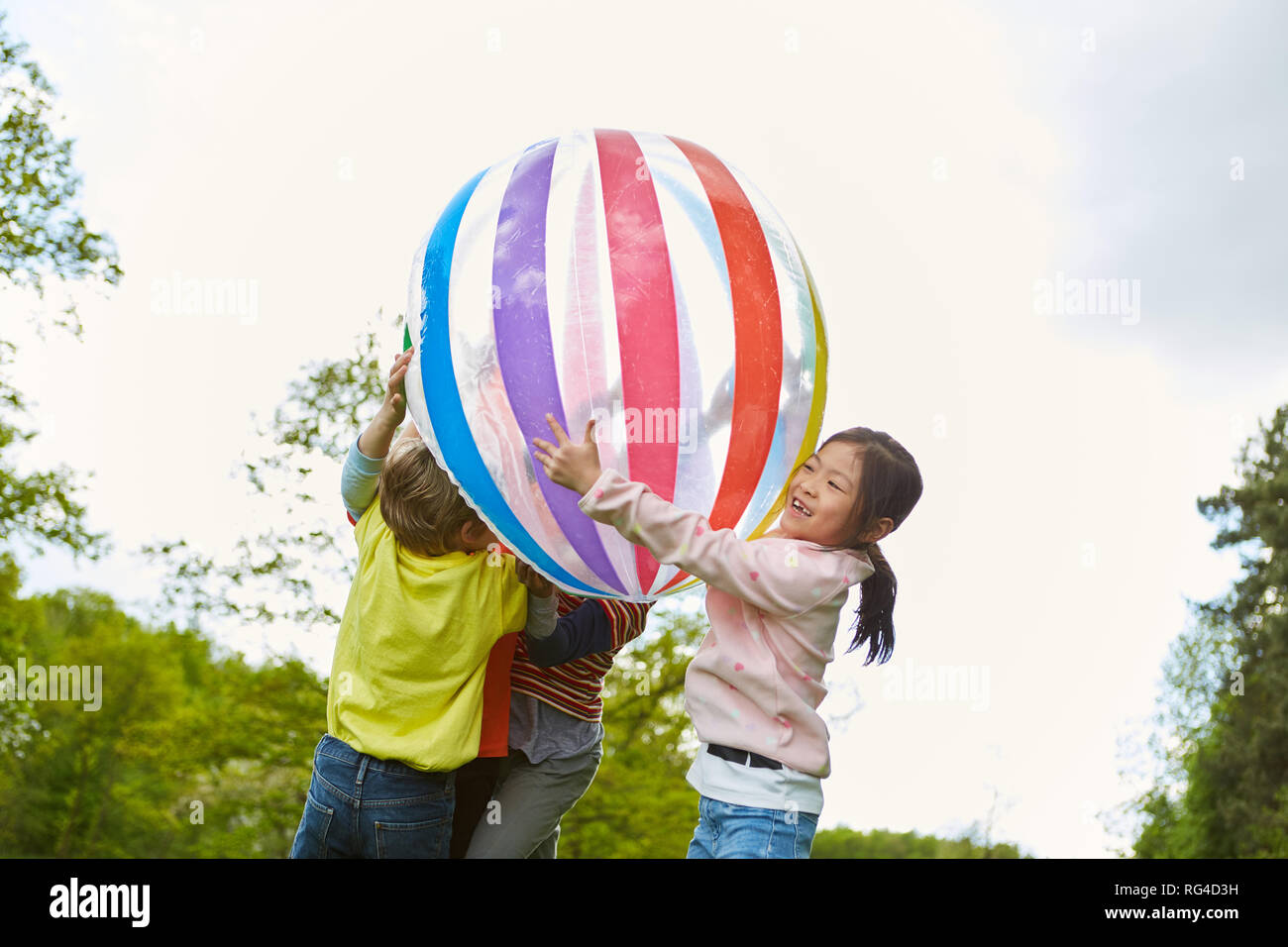 Kindergarten Children have fun playing ball in the park in nature Stock ...