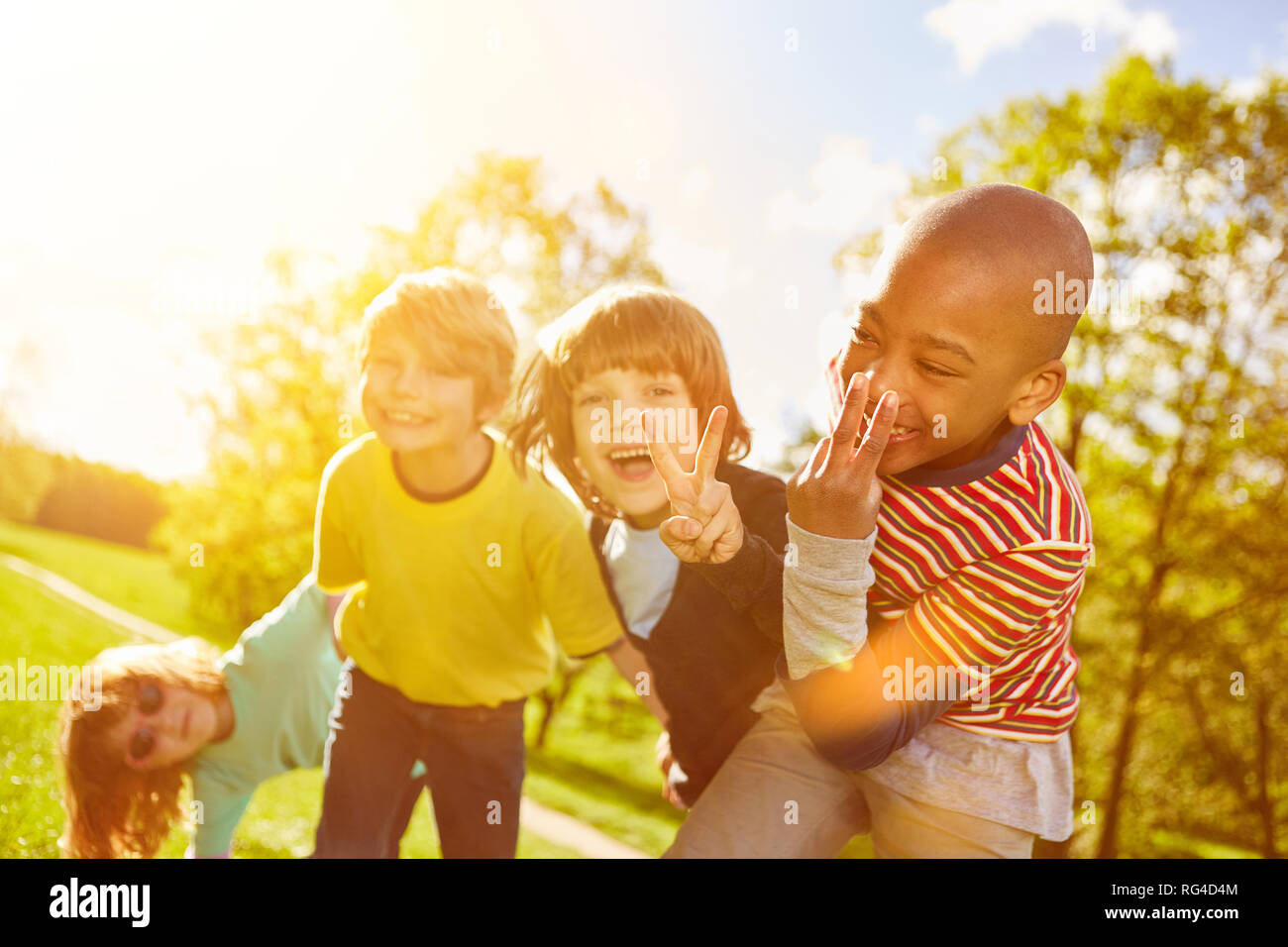 Children have fun together in the summer and show the victory sign by ...
