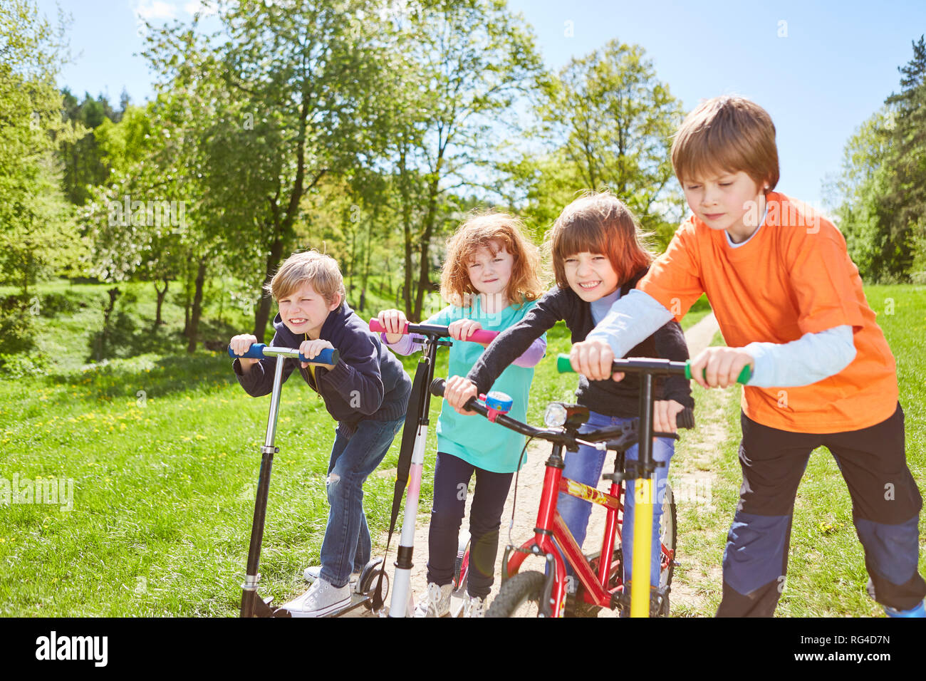 Group of kids at the start before the race with scooter and bike in the ...