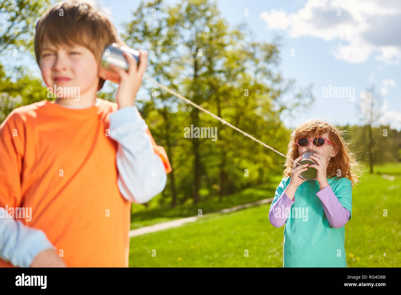 Two children communicate with a corded telephone in a park Stock Photo ...