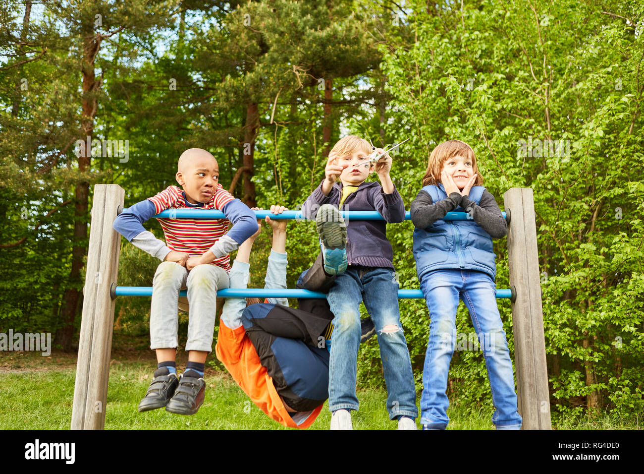 Four children play together on a climbing frame on the playground in ...