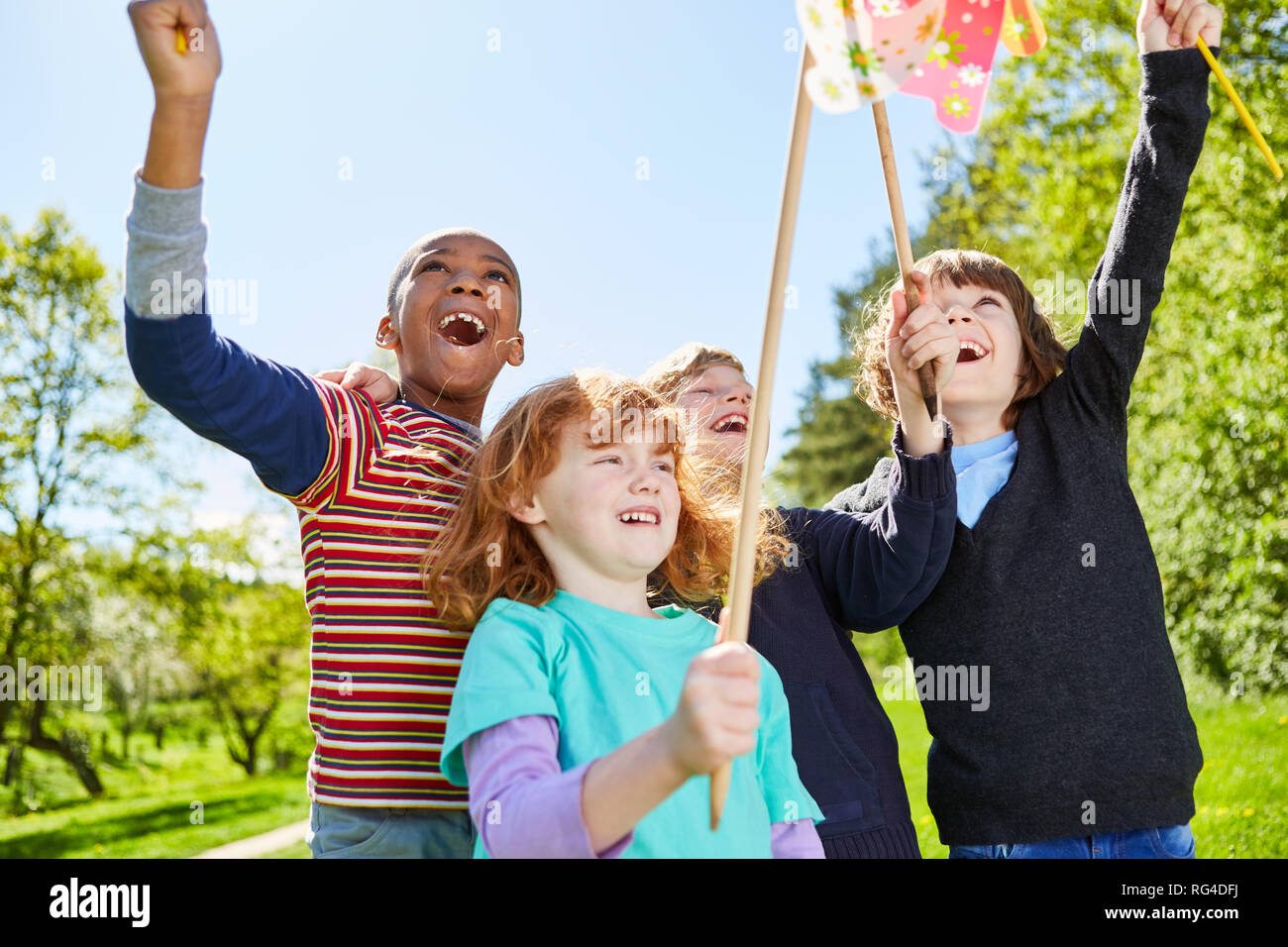 Multicultural kids have fun with colorful windmills on kids birthday ...