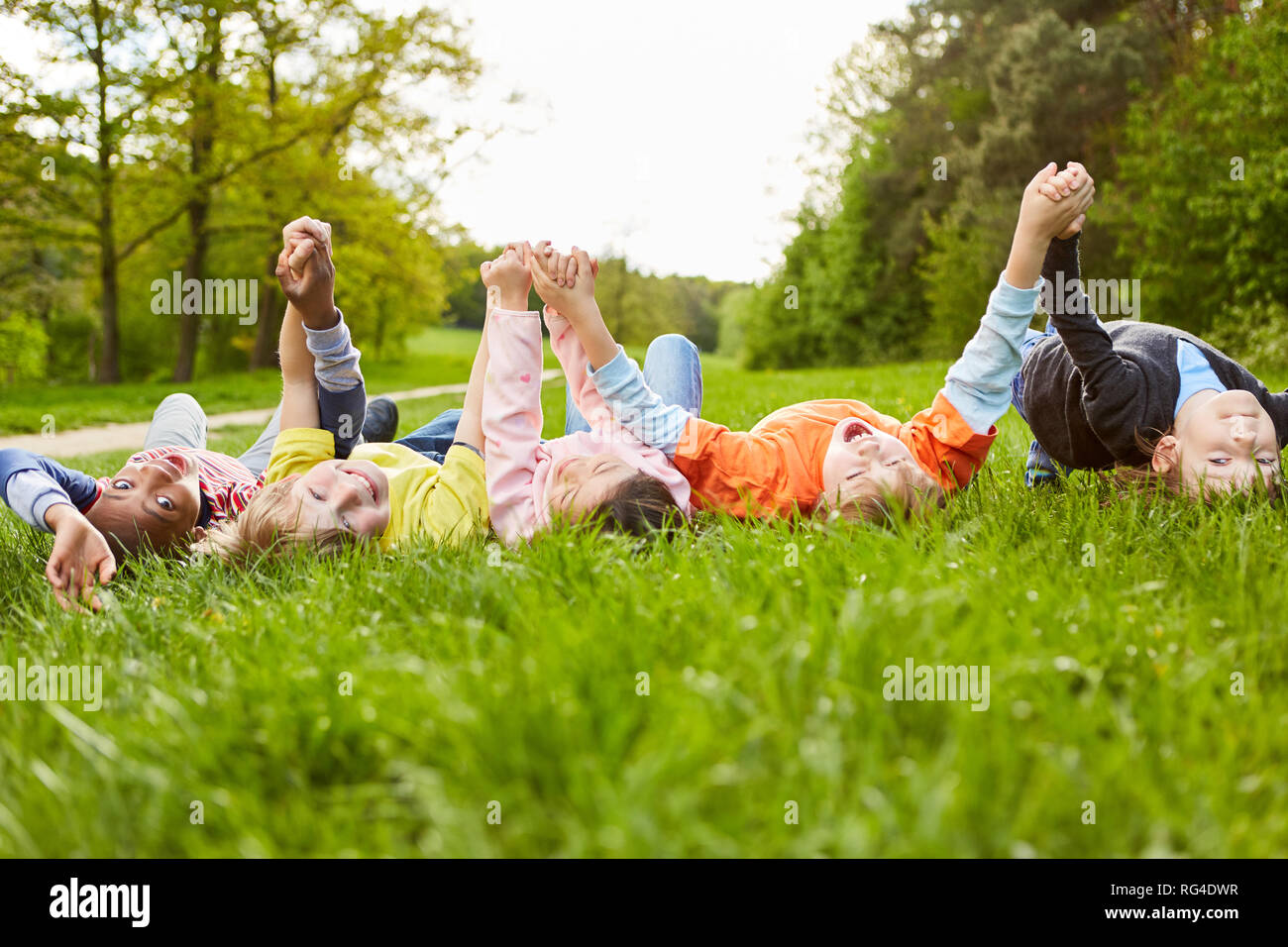 Group of happy kids as friends on a meadow on a tour in the summer ...