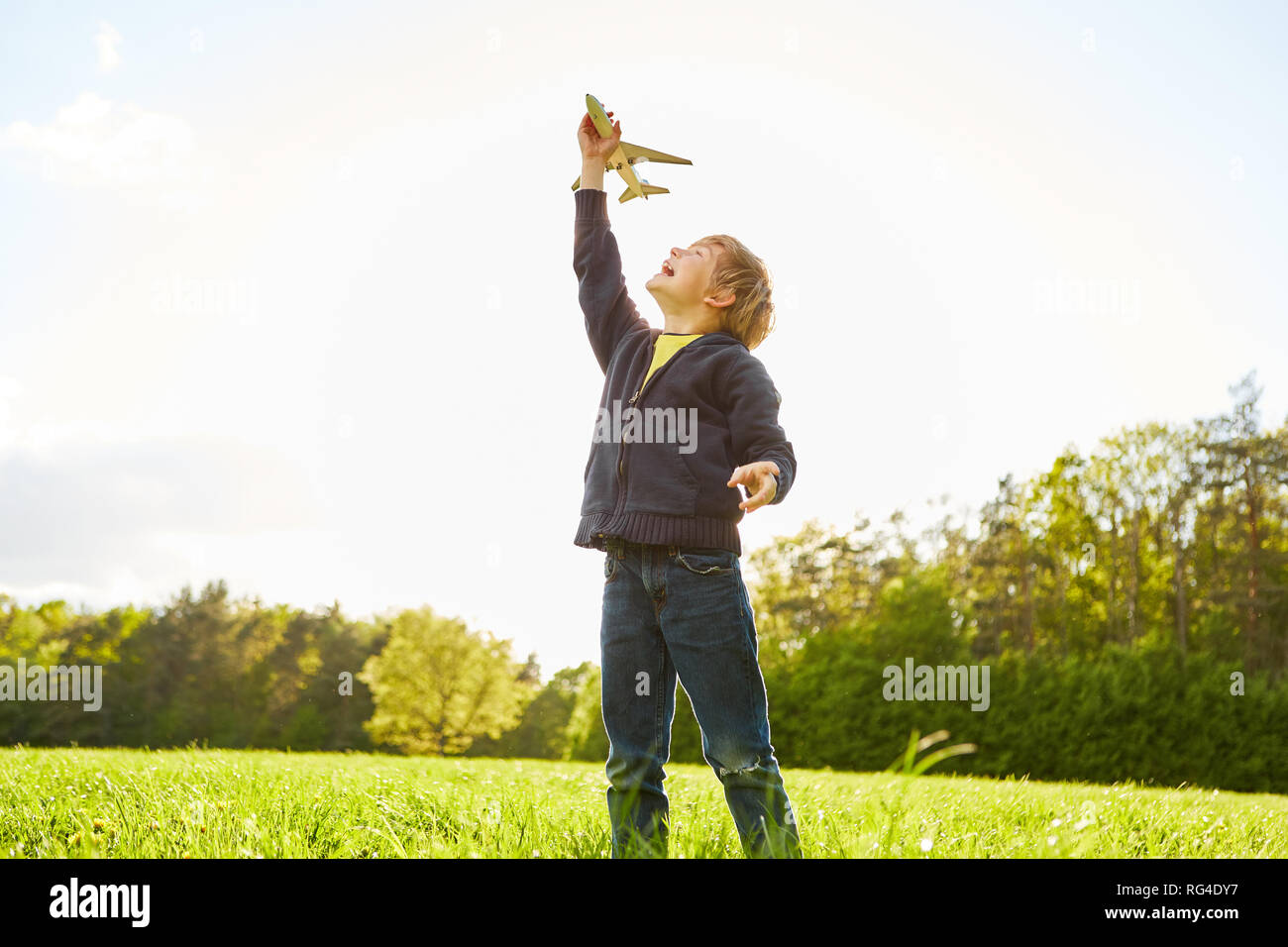 Boy plays in the park with a model airplane and makes it fly in his ...