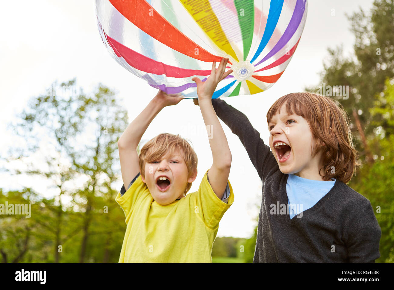 Two cheering children as the winner in a competition with a colorful ...