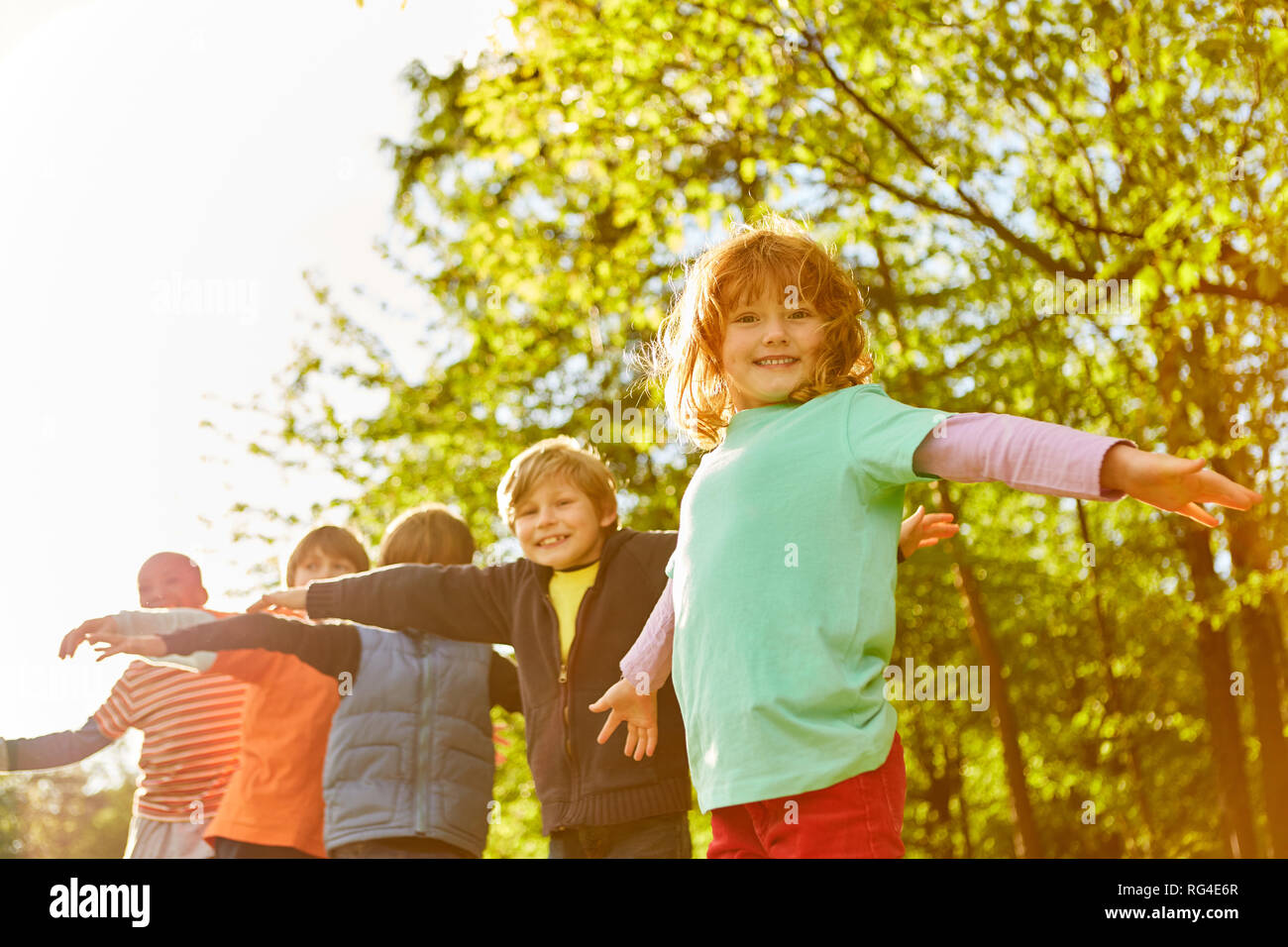 Children play and balance with outstretched arms in the park and have ...
