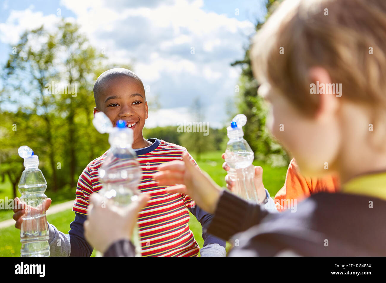 Children in the summer vacation in the park refresh themselves with ...