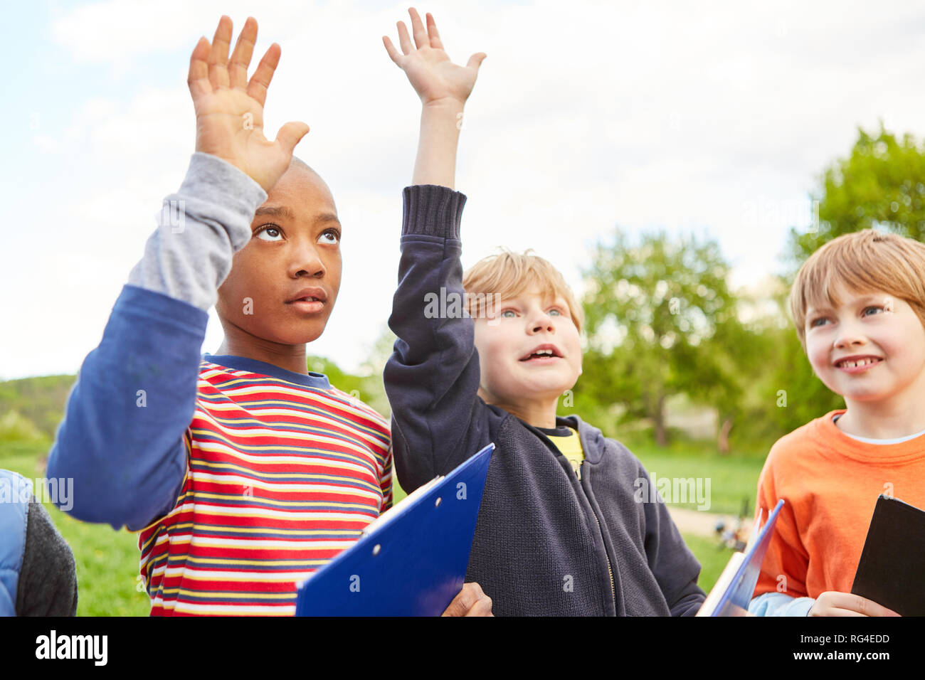 Children as pupils in biology class in nature answer questions in an ...