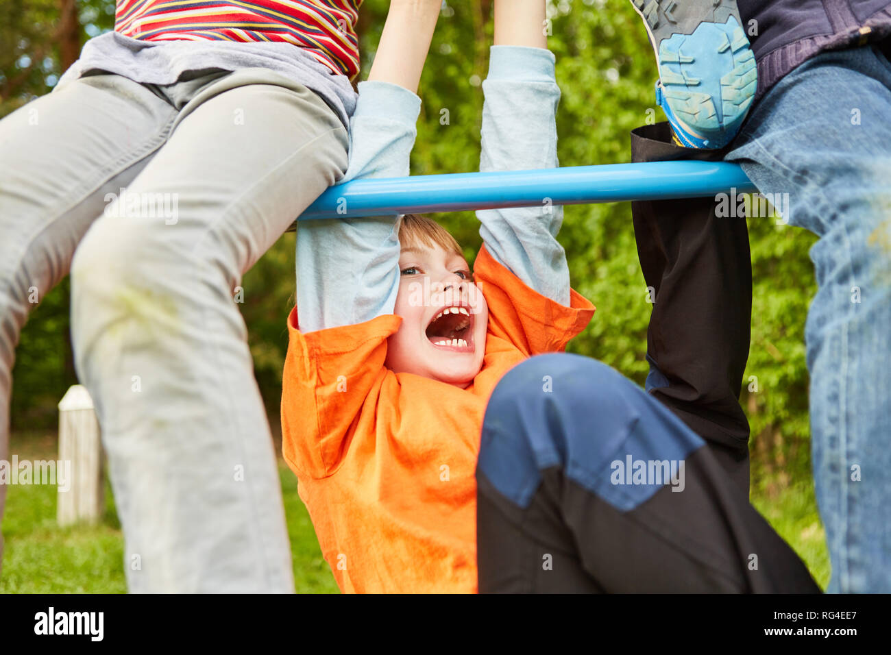 Kids have fun on a jungle gym in the park in the summer and play and ...