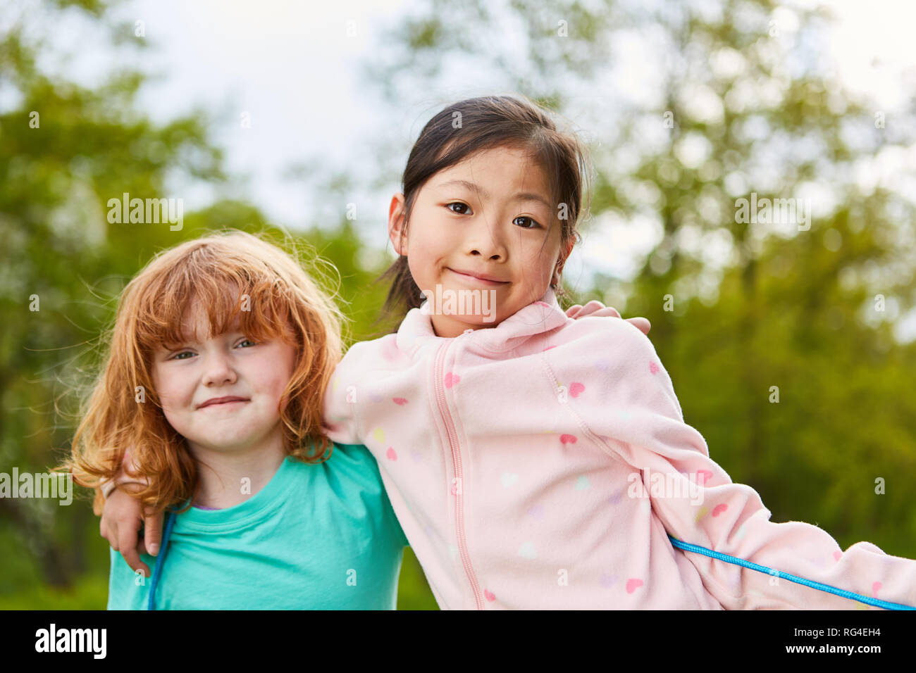 Two girls as best girlfriends together in the park in summer vacations ...