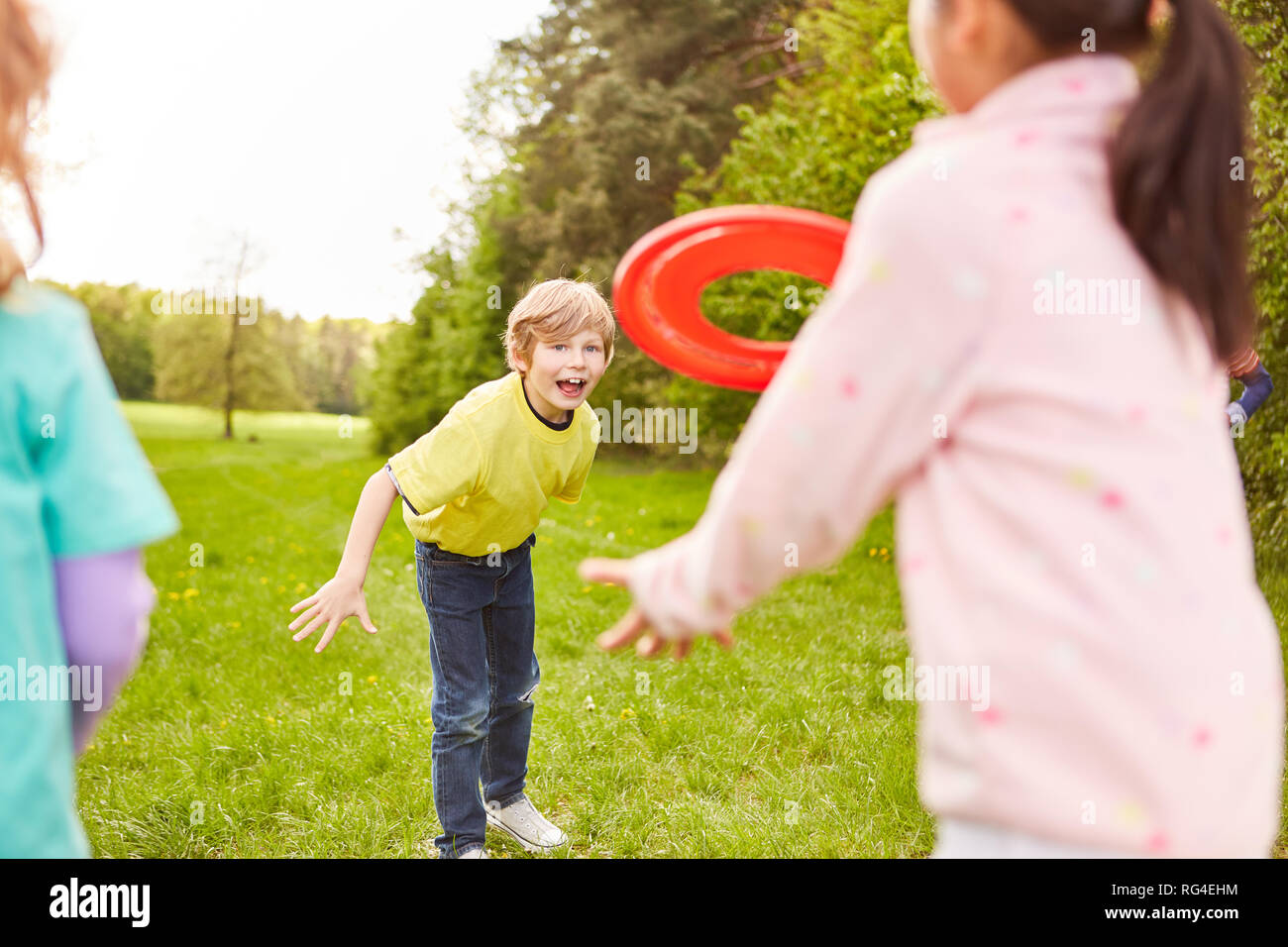 Group of kids playing frisbee in the park in kindergarten or on ...